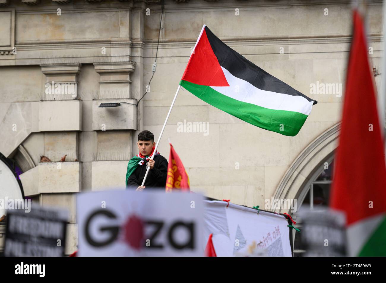 A young man waving a Palestinian flag at the start of a Pro-Palestine ...