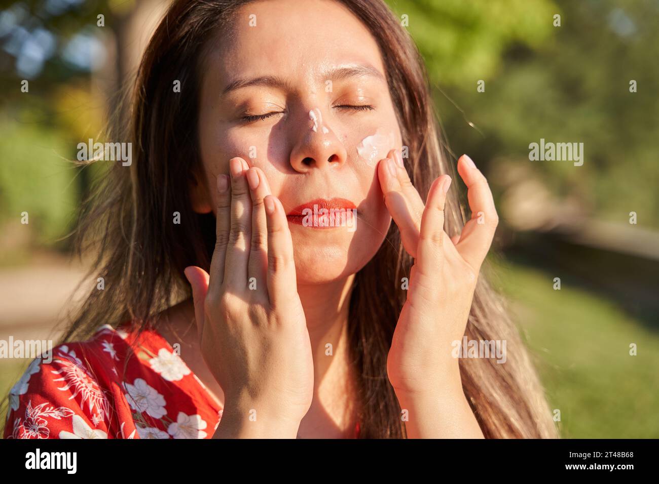 woman using sun tan lotion. young latina putting skin care cream on her ...