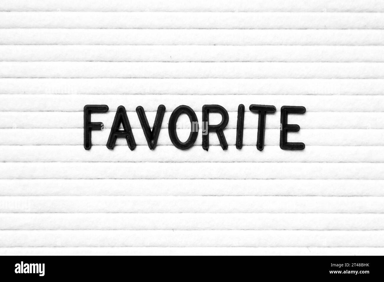 Black color letter in word favorite on white felt board background ...