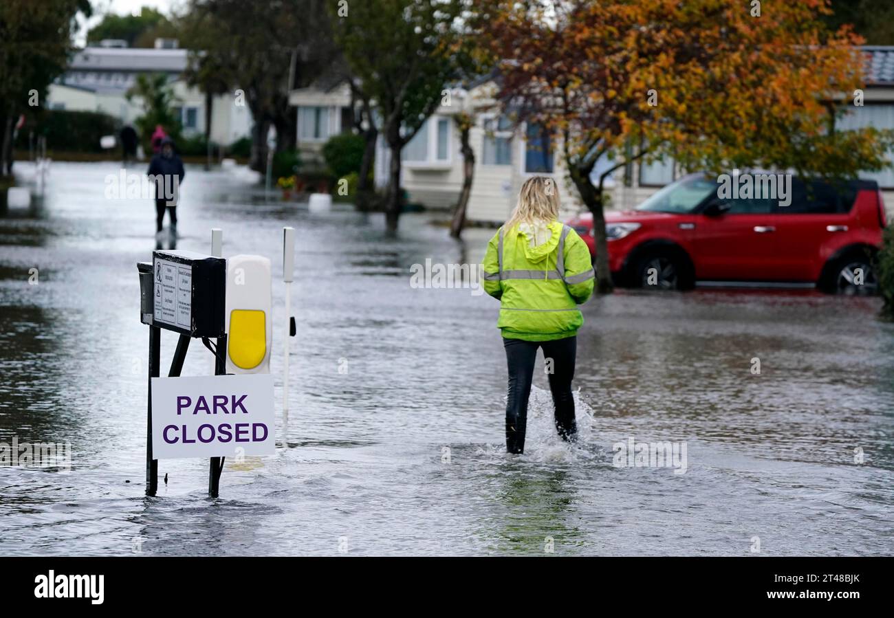 A person walks through flood water at Riverside Caravan Centre in ...