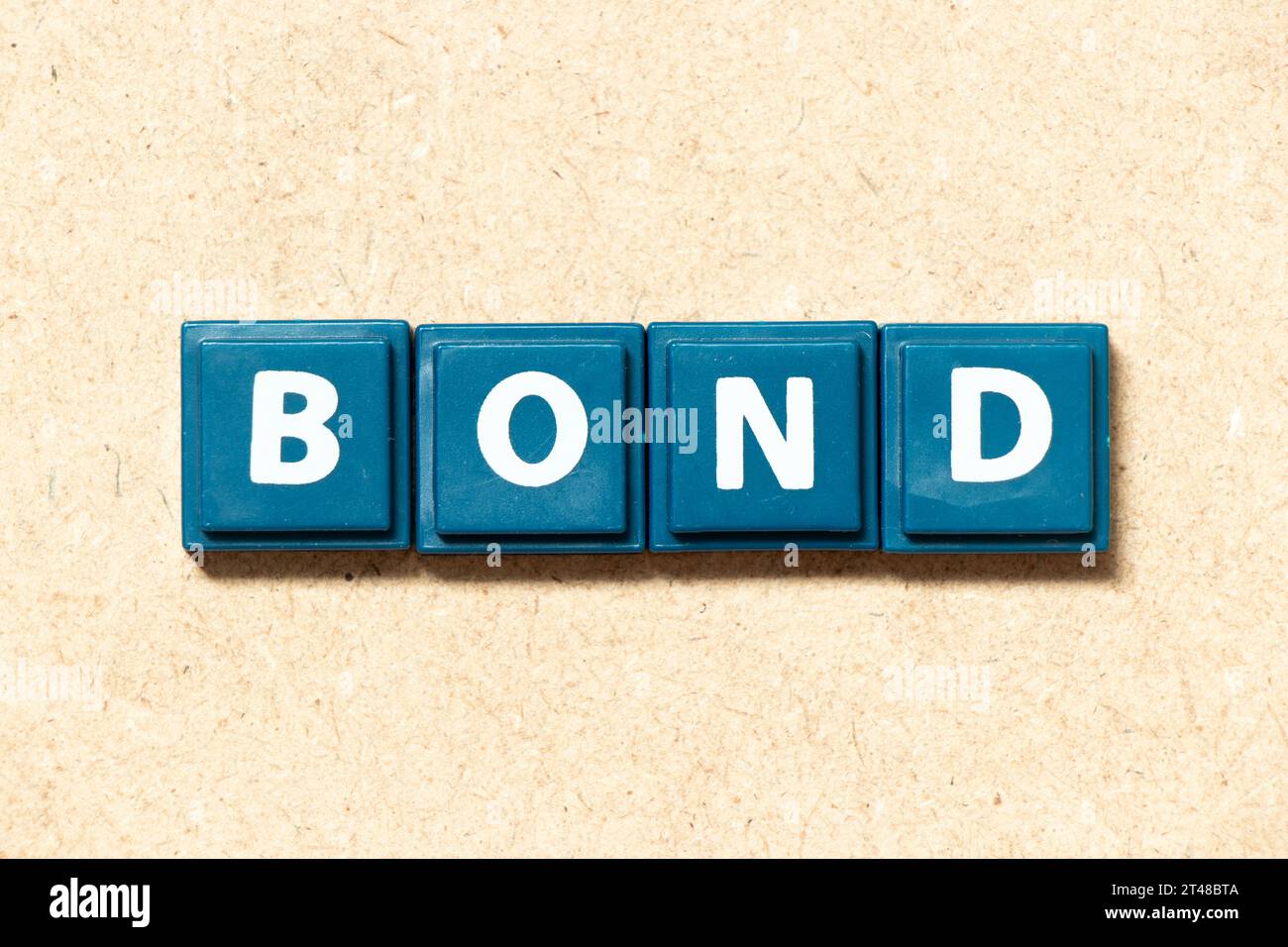 Tile alphabet letter in word bond on wood background Stock Photo - Alamy