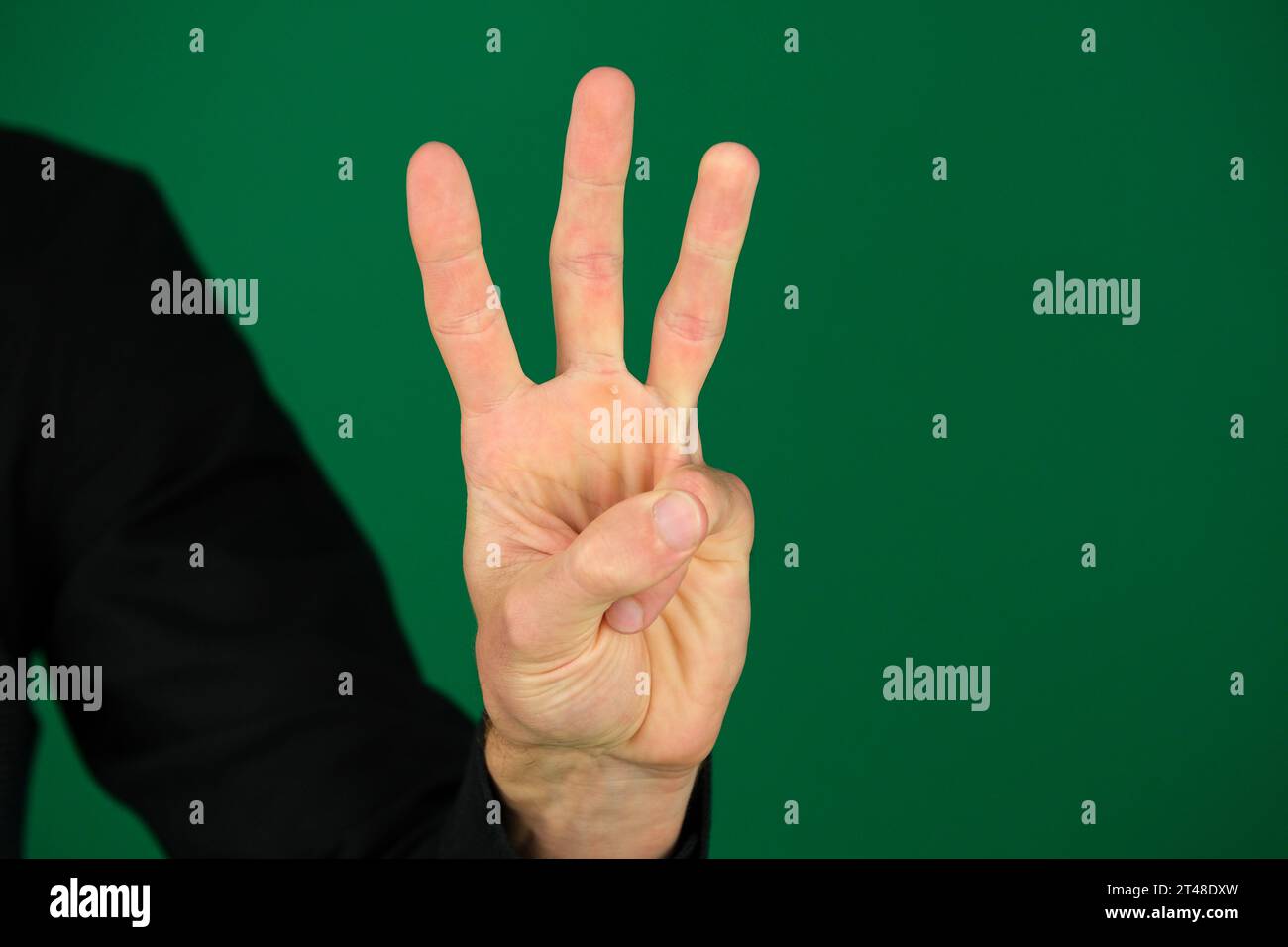 a raised three fingers like a Germany, hand symbol, viewed from back isolated on white ...