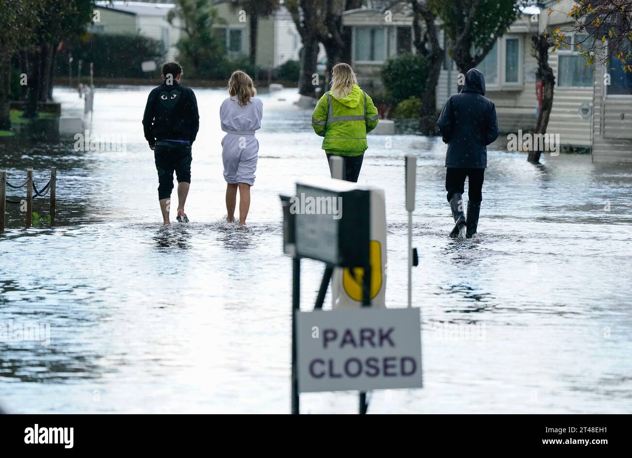 People walk through flood water as they make their way into the ...