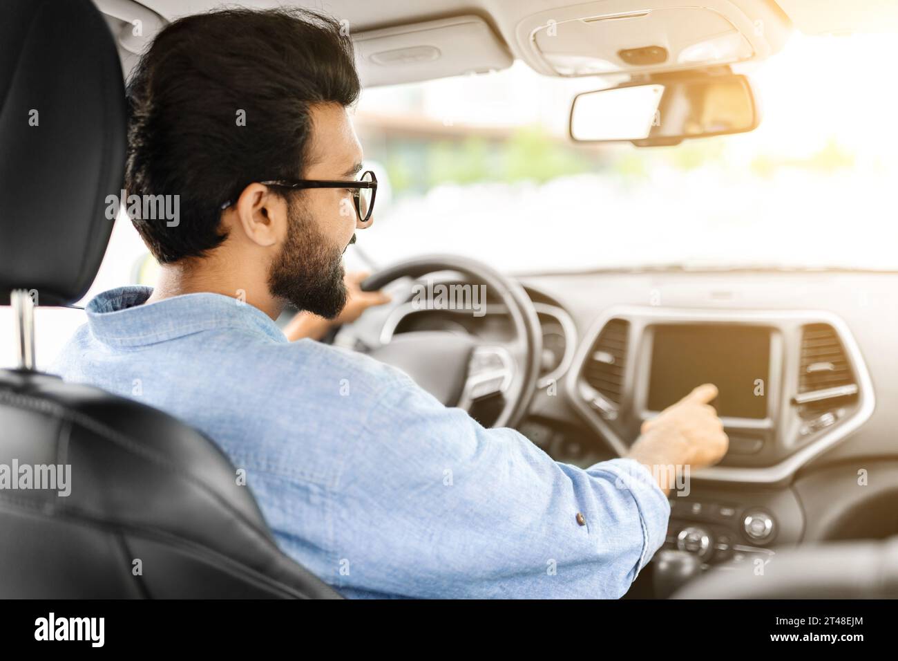 Happy young indian man driving car and listening to music Stock Photo ...