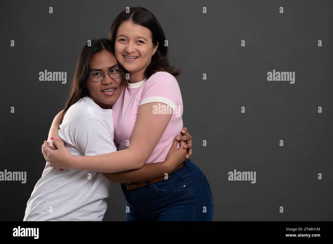 Portrait of two hugging young people with smiling teeth brackets on ...
