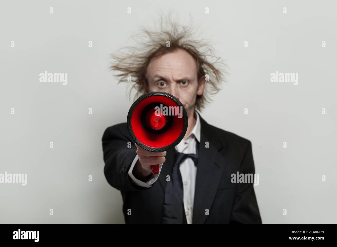 Red loudspeaker in hand of crazy businessman on white background Stock ...