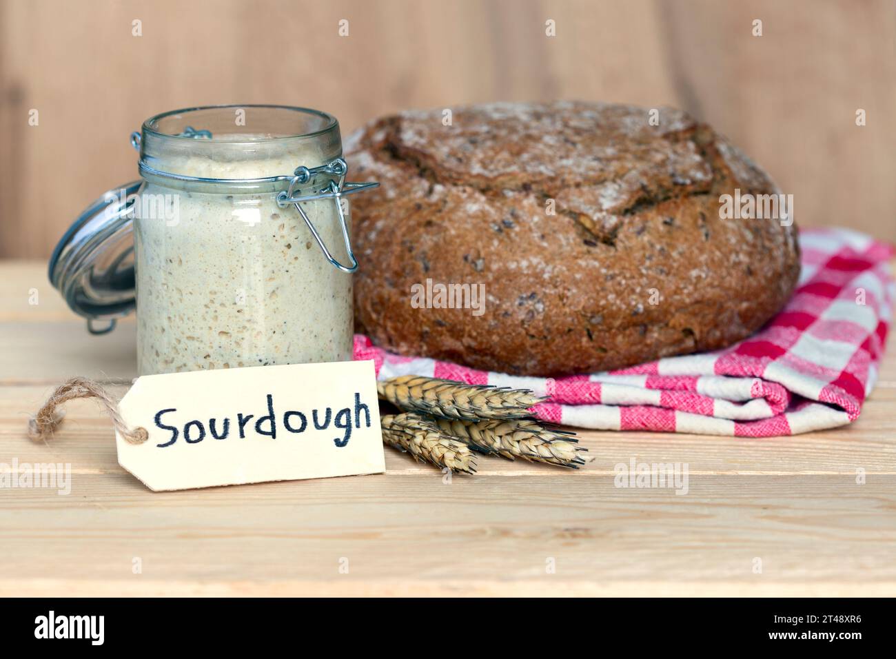 sourdough label with yeast jar, bread, wheat ears on wooden background ...