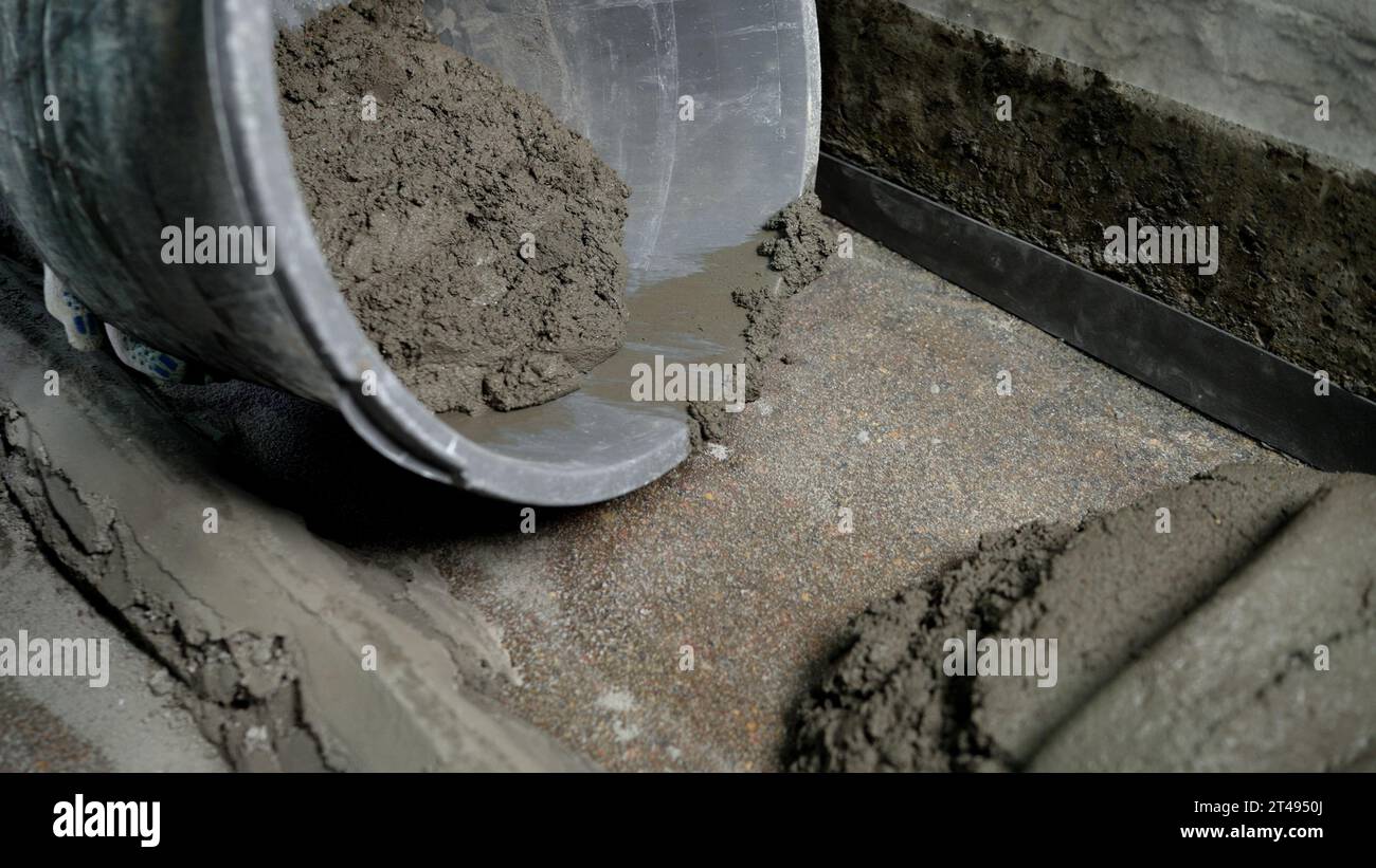 Close-up of a construction worker working on a floor. Floor screed with ...