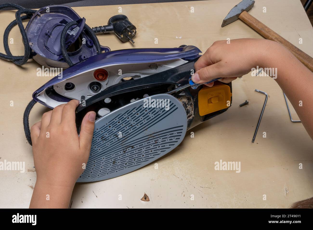 Disassembled electric iron. repairman checking and fixing broken iron ...