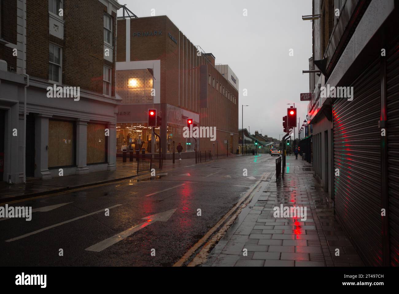 Dark Moody street looking up towards the traffic lights on an early ...