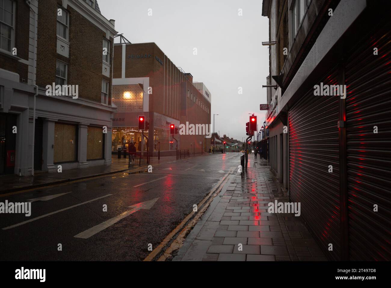 Dark Moody street looking up towards the traffic lights on an early ...