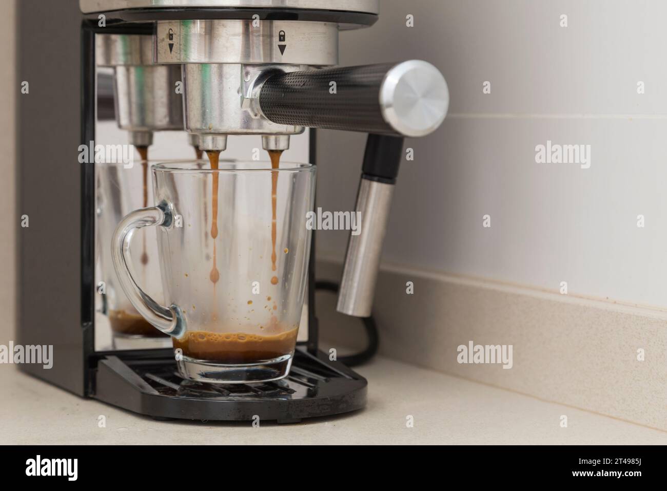 espresso coffee maker making coffee, the coffee jets fall onto the ...