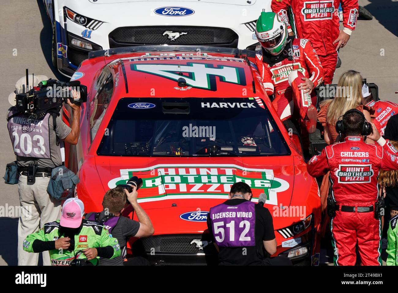 Kevin Harvick, left, climbs into his car before a NASCAR Cup Series ...