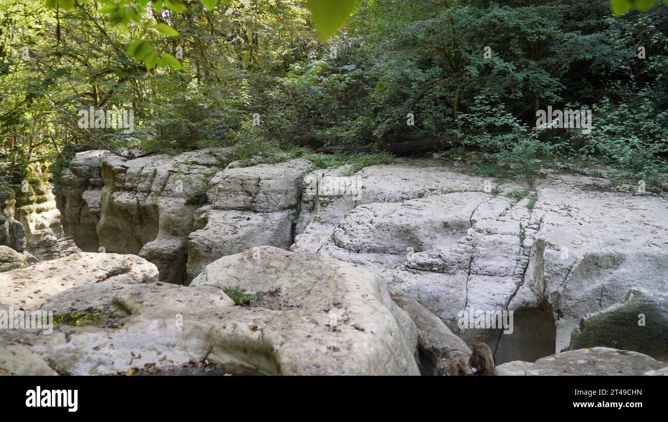 Waterfall in a crevice between the rocks behind the trees. Canyons of ...