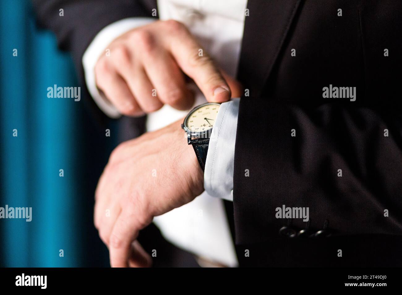 Man adjusts time on wristwatch, symbolizing precision and elegance ...