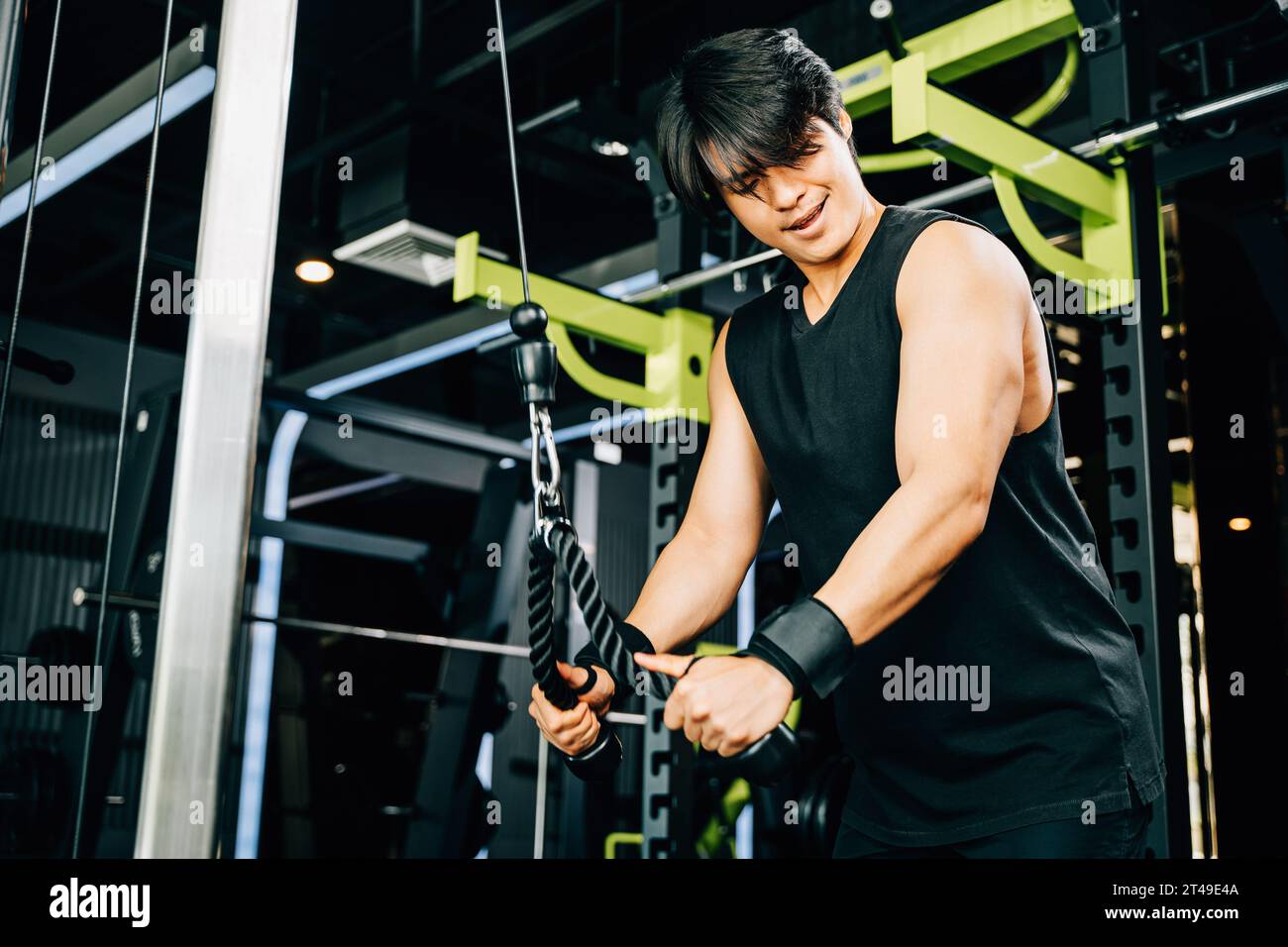 Young man performing cable triceps pulldowns to build muscle and ...