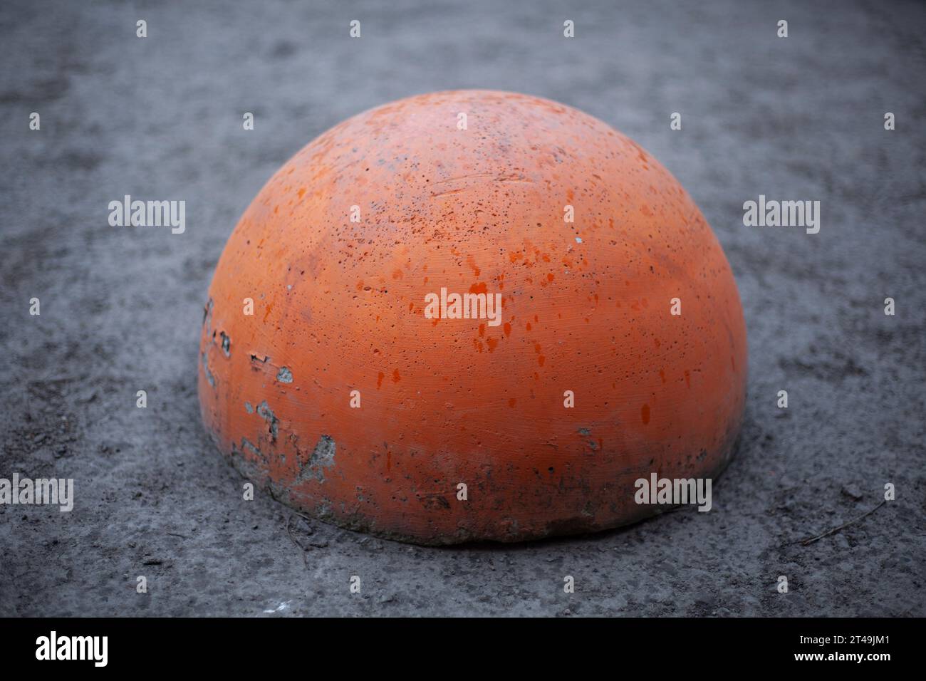 Sphere in the parking lot. Motion limiter. Orange sphere on asphalt ...