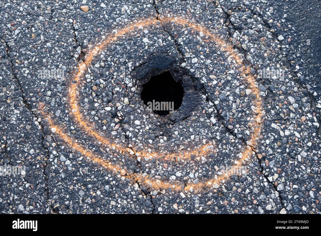 A pothole marked for repair on a country road in summer in the Kajaani ...