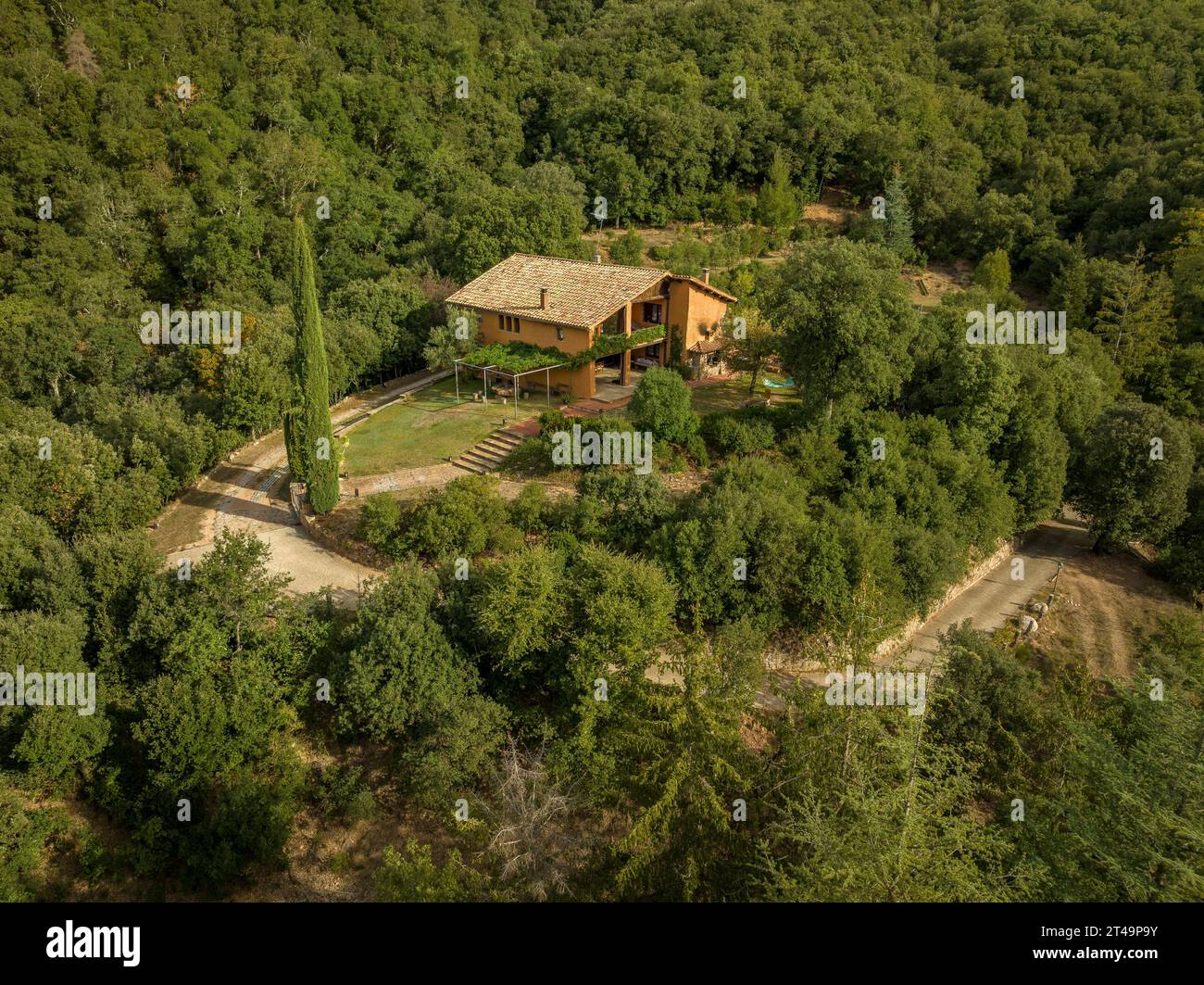 Aerial view of the Can Xisquet rural house, surrounded by forest near ...
