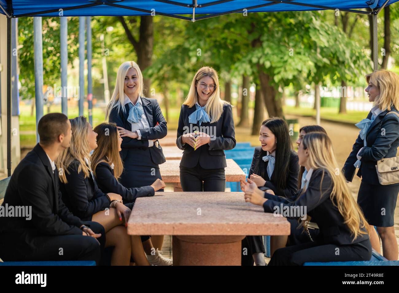 Group of students gathered at table having a conversation during break ...