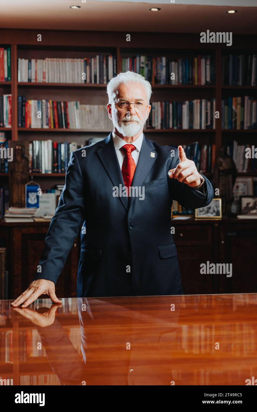 Experienced Rector Posing in Academic Library with Bookshelf Stock ...