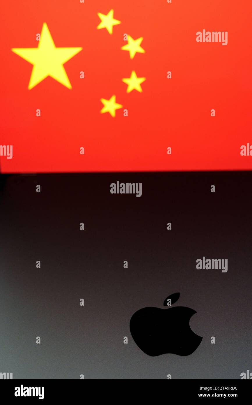Apple logo seen on IPad and blurred flag of China at the background ...