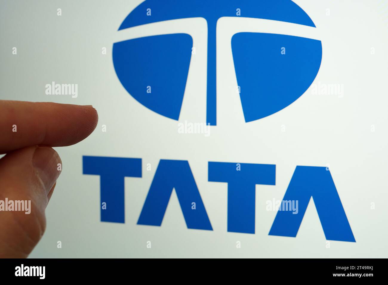 Tata Group logo seen on the screen and finger touching it. Concept ...