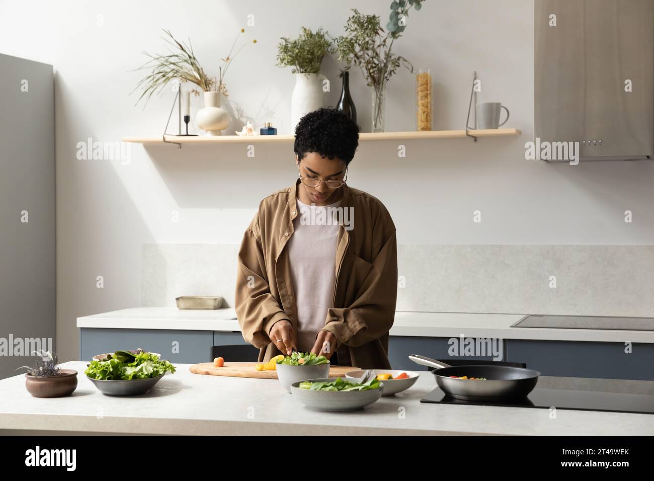 Serious young Black chef woman cooking dinner in kitchen Stock Photo ...