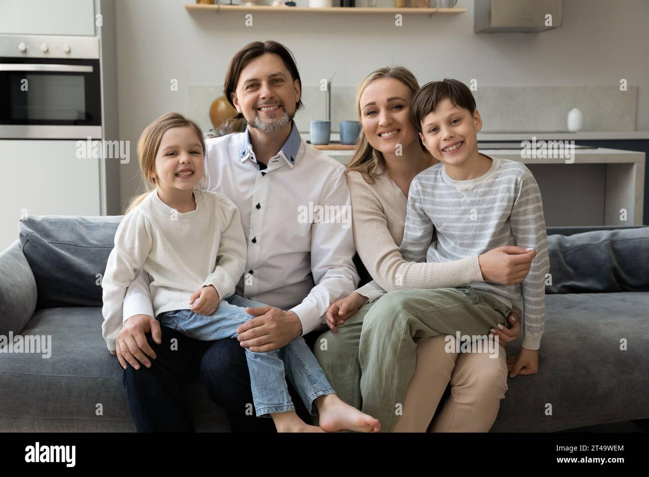 Joyful parents holding daughter and son kid on laps Stock Photo - Alamy