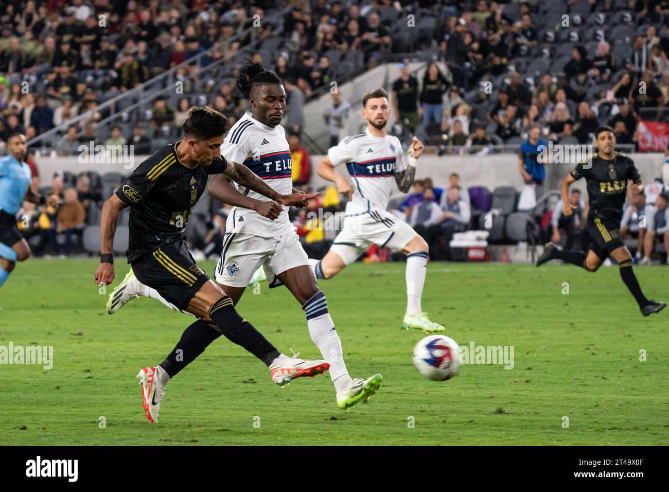 LAFC forward Cristian Olivera (25) shoots against Vancouver Whitecaps defender Sam Adekugbe (3 ...