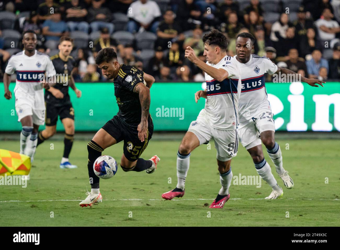 LAFC forward Cristian Olivera (25) is defended by Vancouver Whitecaps midfielder Alessandro ...