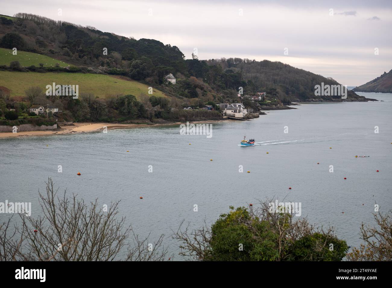 View of fishing boat sailing along Salcombe Estuary away from the sea ...