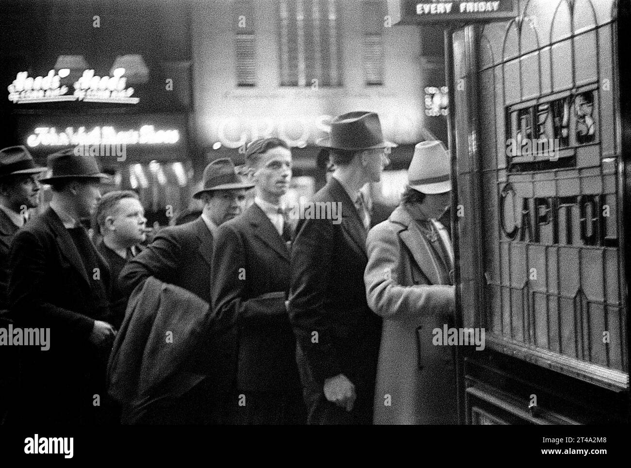 Street scene with people waiting in line for tickets outside Loew's ...
