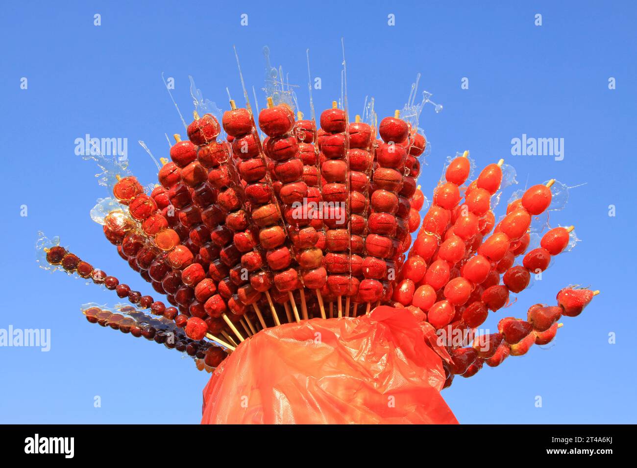 sugar-coated haws on a stick under the blue sky Stock Photo - Alamy