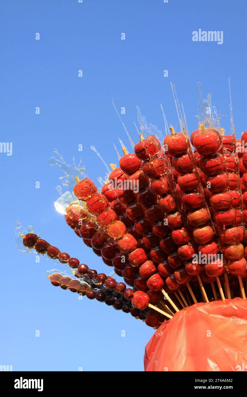 sugar-coated haws on a stick under the blue sky Stock Photo - Alamy