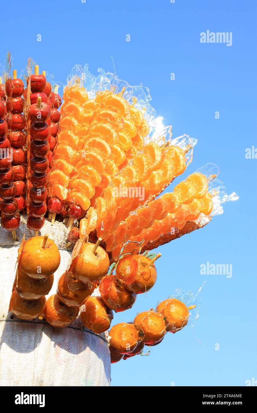 sugar-coated haws on a stick under the blue sky Stock Photo - Alamy