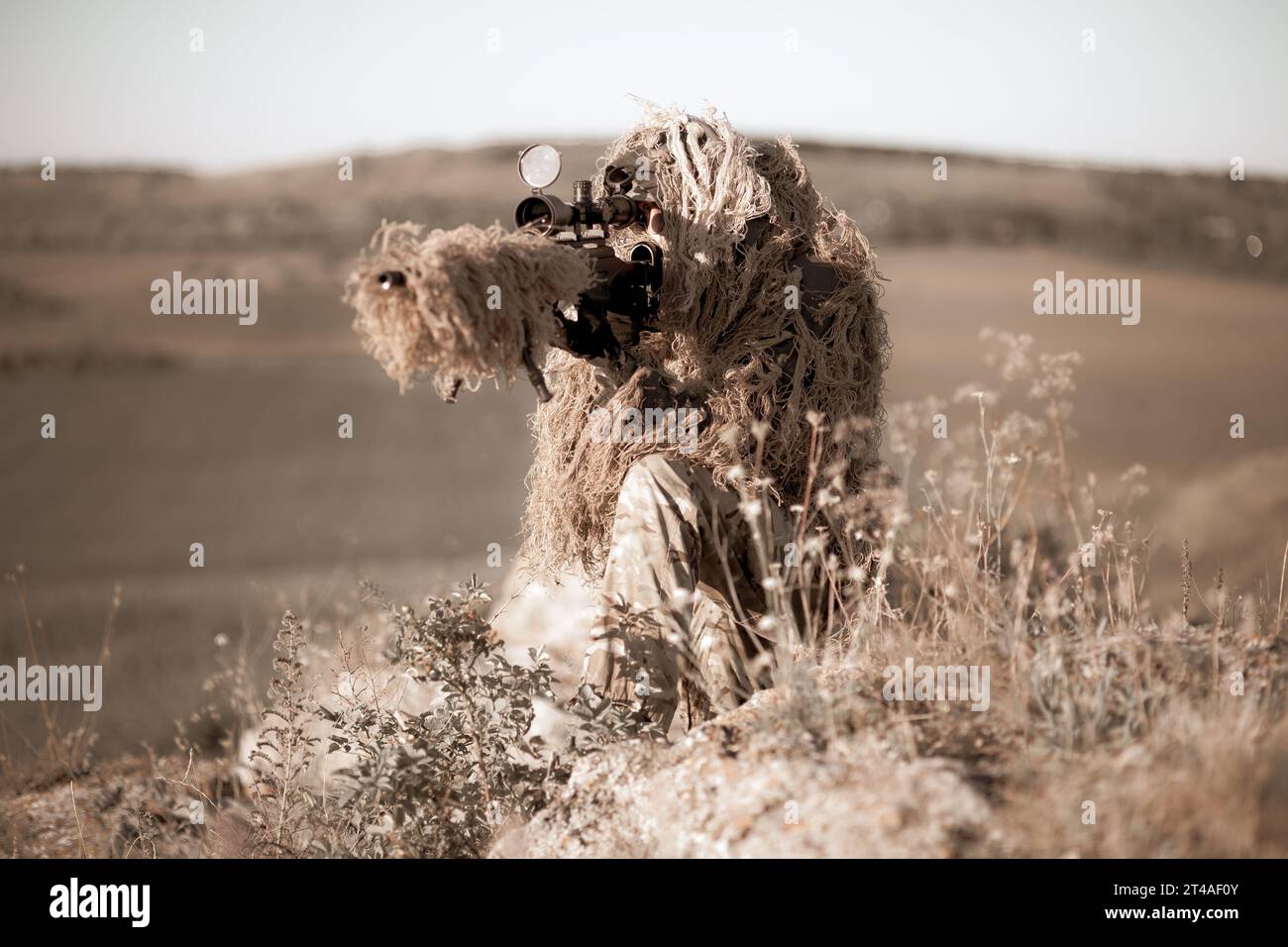 Special forces sniper in ghillie suit with a high-precision rifle with ...
