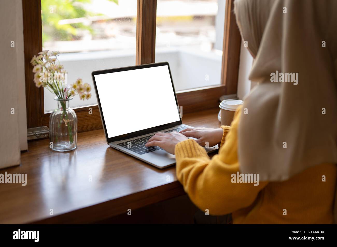 Back view image of a Muslim woman typing on her laptop keyboard, using ...