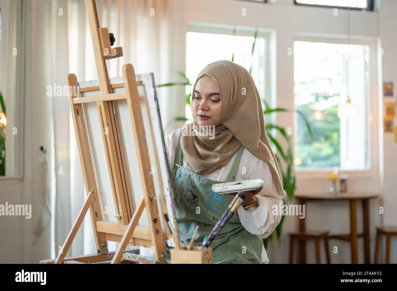 A concentrated and creative Asian-Muslim female artist creating her ...
