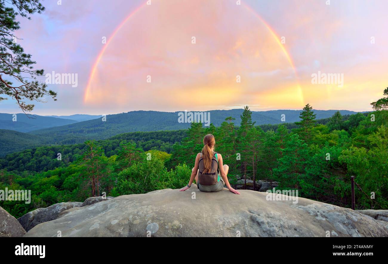 Hiker woman resting on rocky mountain top enjoying morning nature ...