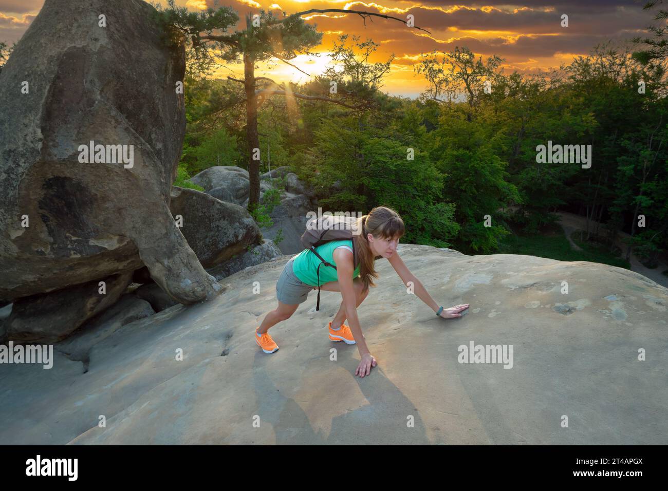 Young woman climbing alone on rocky mountain path. Female hiker ...