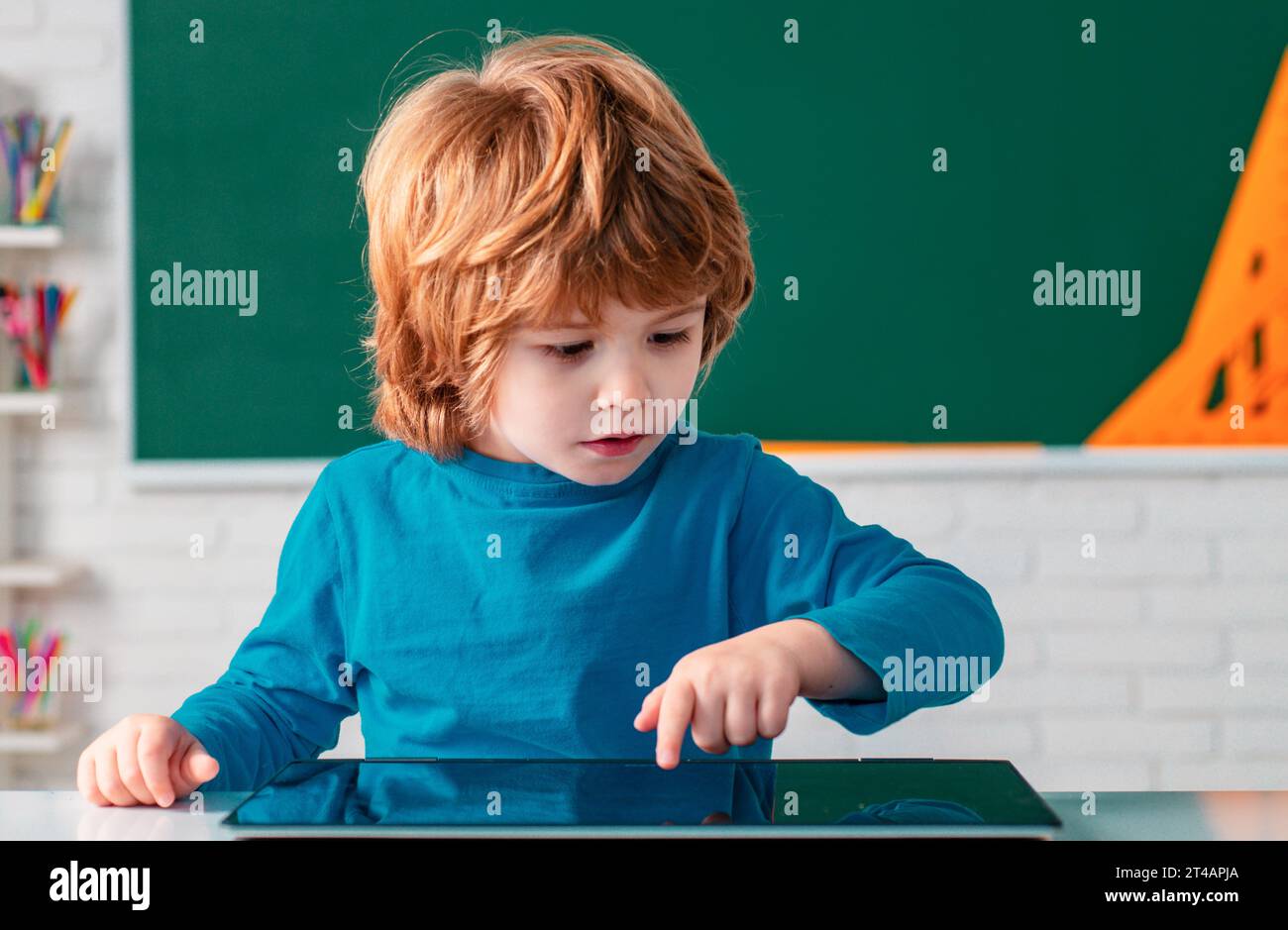 School child with tablet in school classroom. Children learning. Kids ...