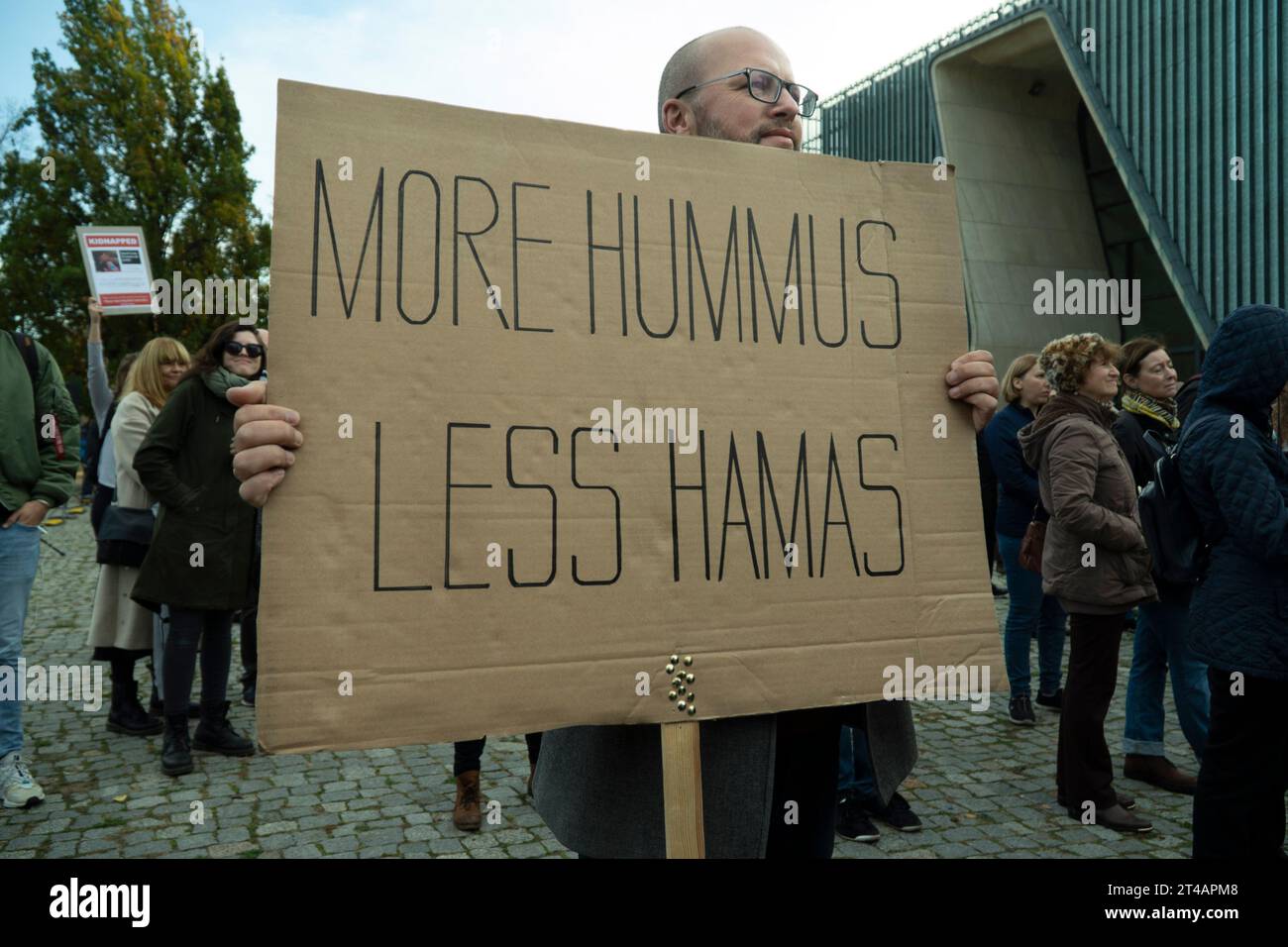 A man holds a sign reading 'More hummus less Hamas' during a vigil in ...