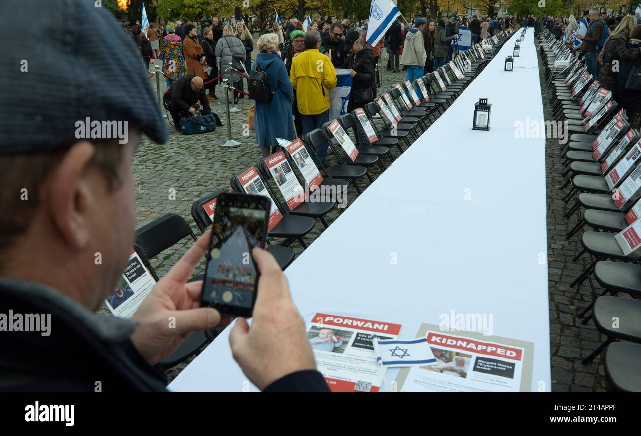 A man takes a photograph of sign with photos and names of vicitims in ...