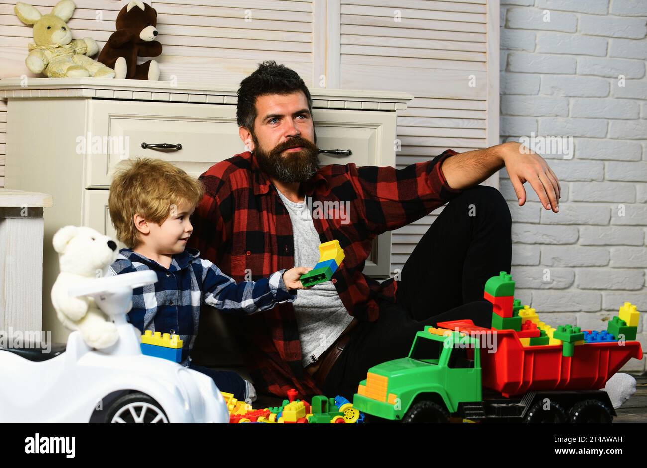 Father and son create toys from bricks. Cute little kid son play toy ...