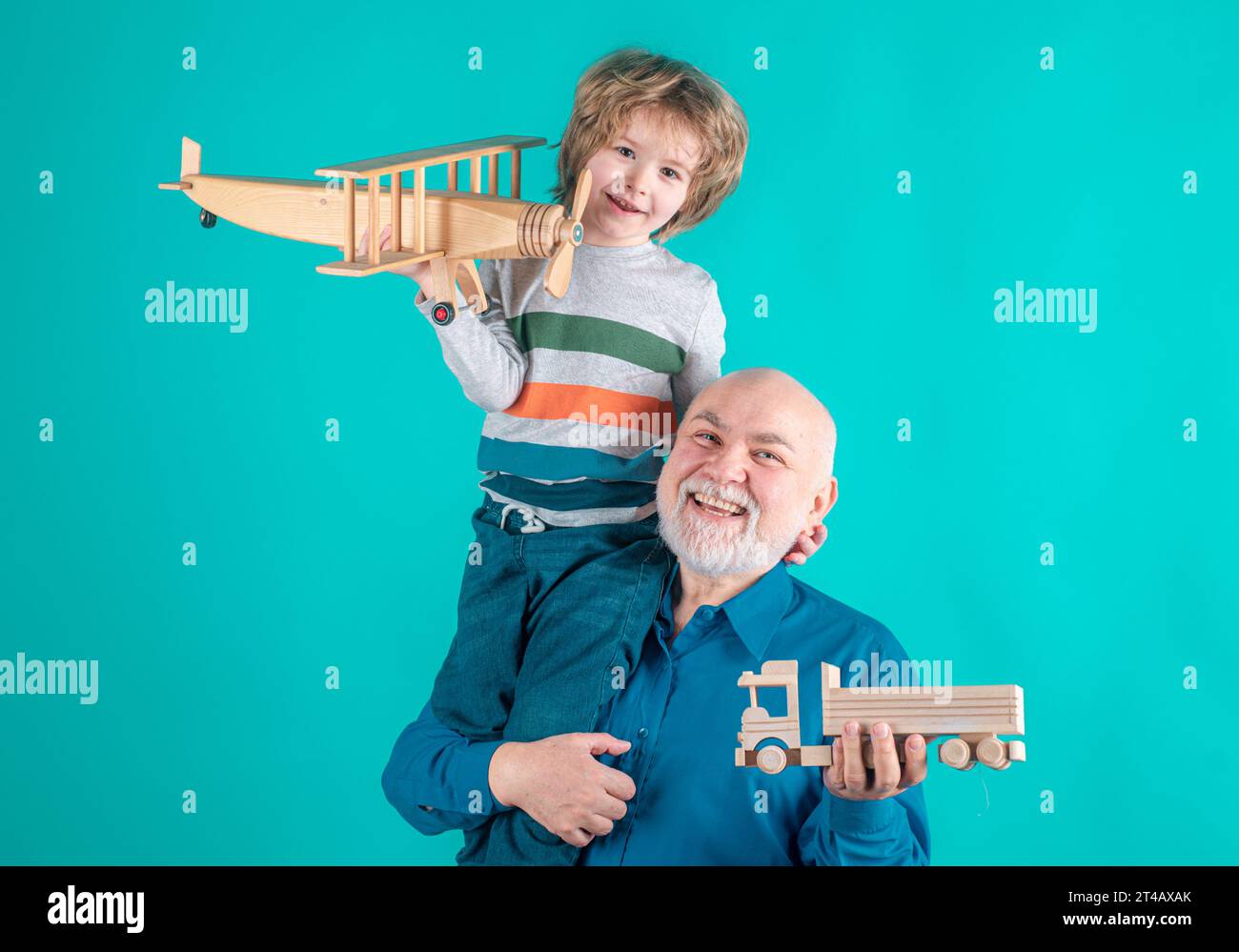 Old grandfather and young child grandson piggyback with toy plane and ...