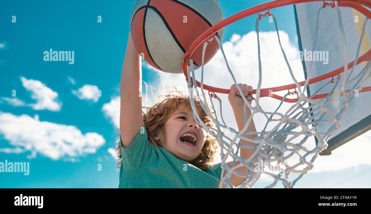 Close up image of kid basketball player making slam dunk during ...