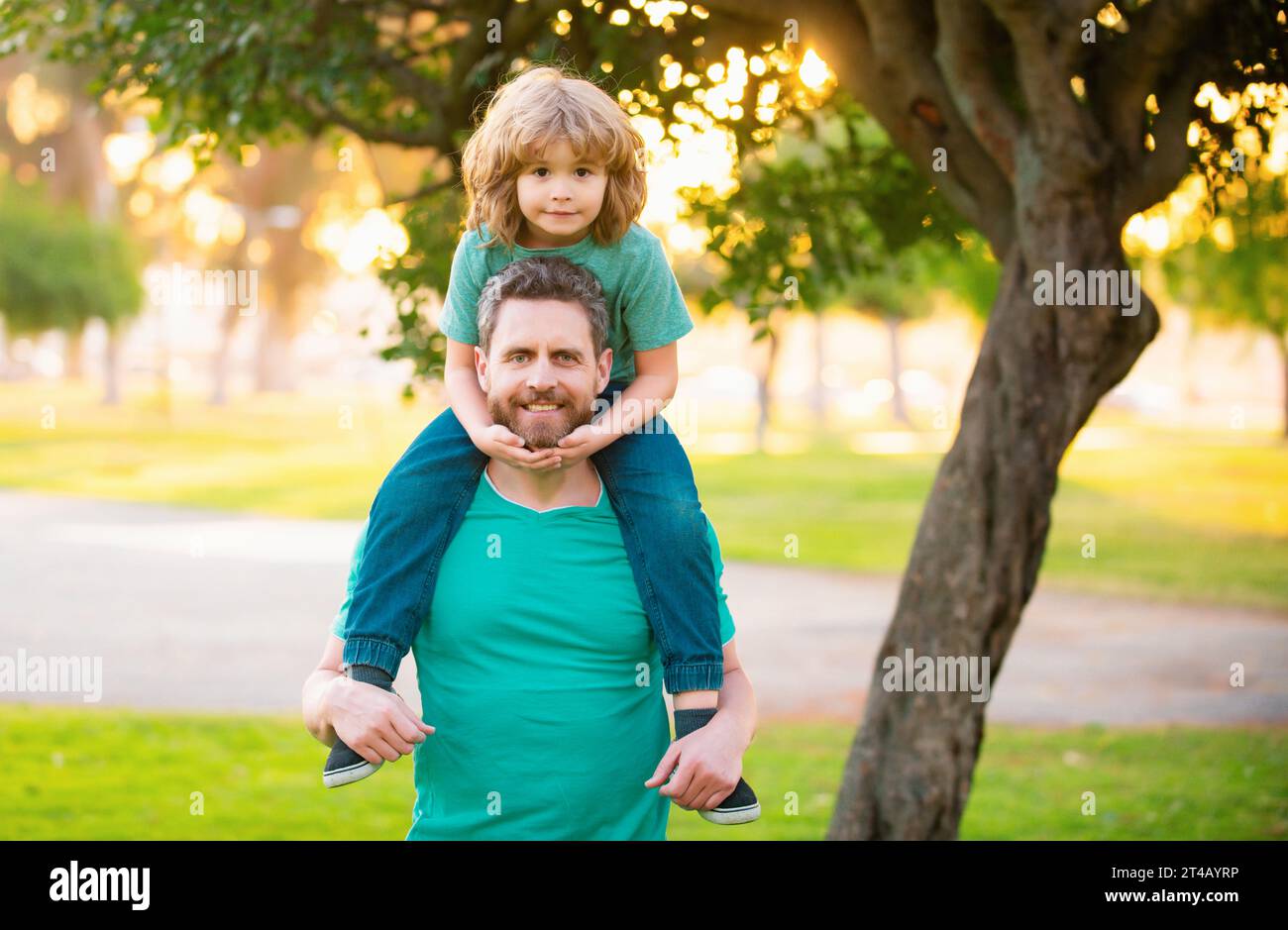 Dad and child having fun outdoors. Father giving son ride on back in ...