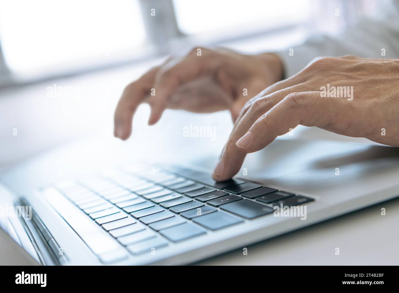 Closeup of businessman's hands typing on a laptop computer for data ...