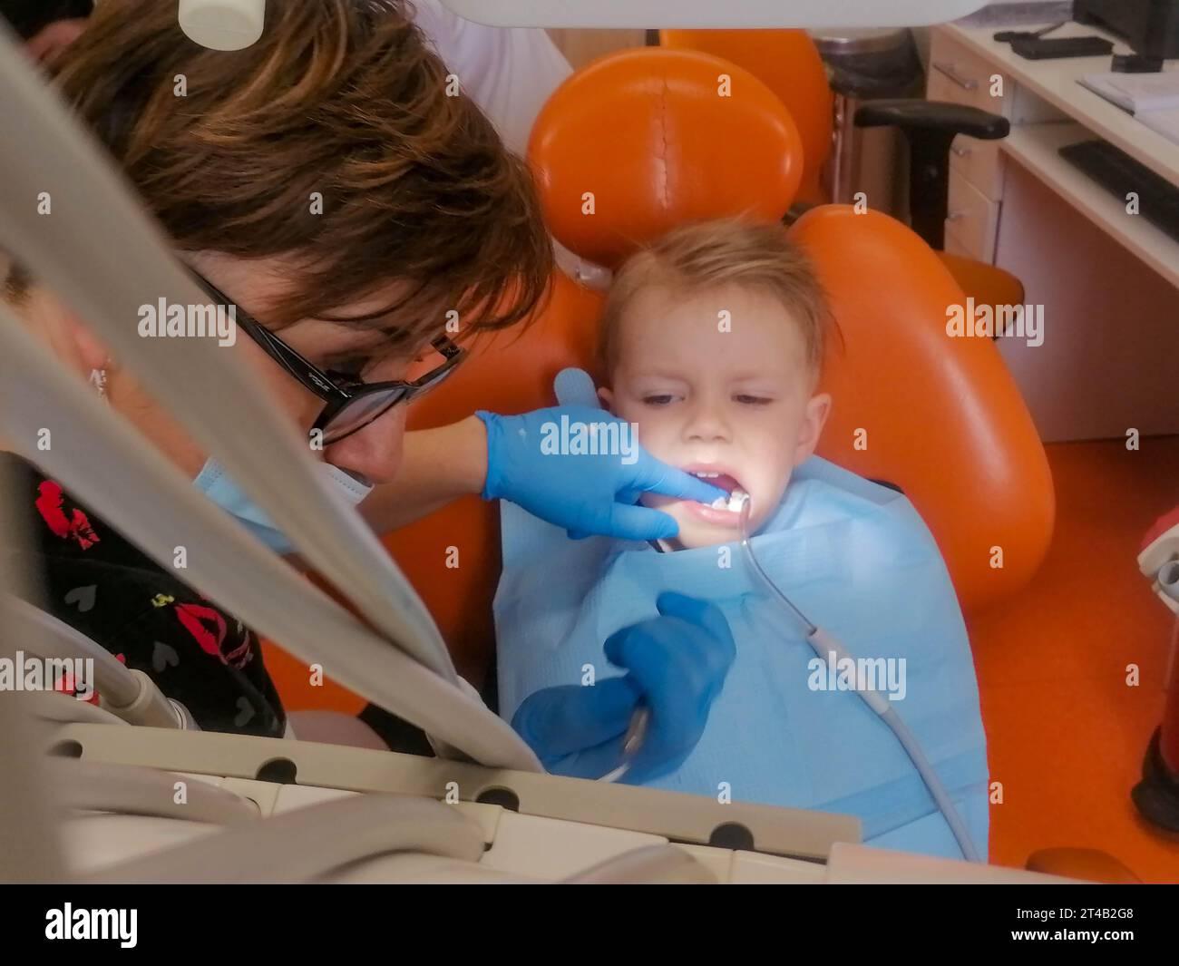 Female dentist examines the teeth of the patient cheerful child with ...